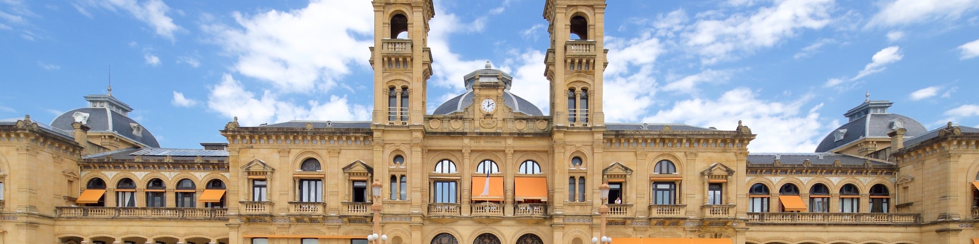 Um edifício histórico com duas torres, uma cúpula central e uma entrada imponente.