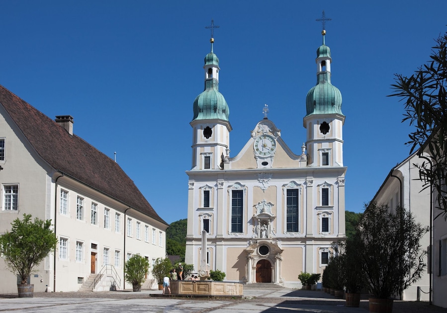 Uma igreja histórica com duas cúpulas verdes e um campanário.