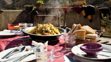 Uma mesa posta com comida e bebidas, com uma cordilheira ao fundo.