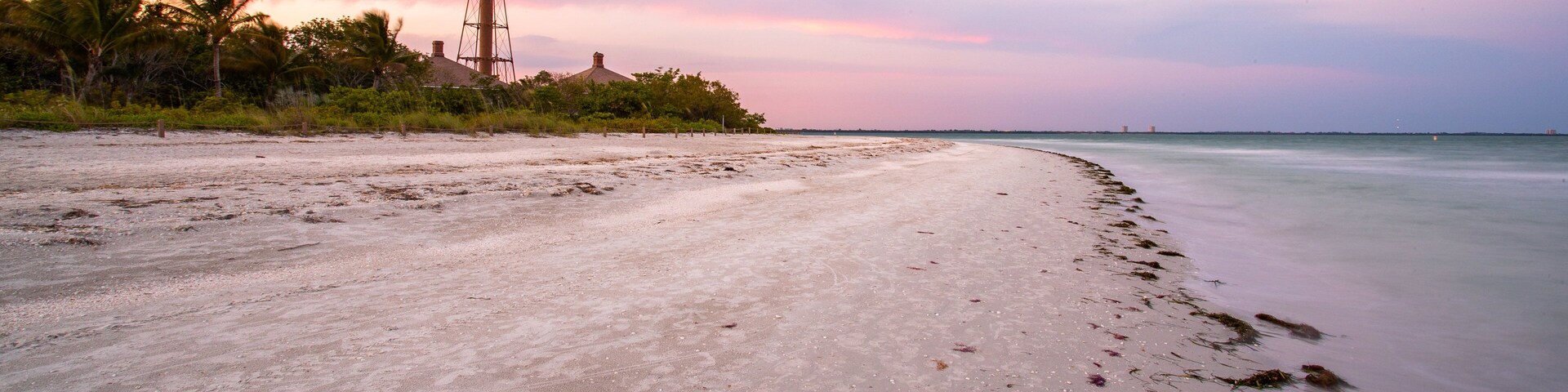 Sanibel Island Lighthouse which includes a beach, general coastal views and a sunset