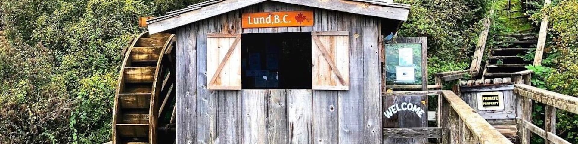 Uma estrutura de madeira com uma placa indicando "Lund B.C." e uma placa com a palavra "BEM-VINDO".