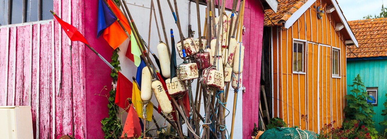 Um chalé de pesca colorido com vários equipamentos e bandeiras vibrantes.