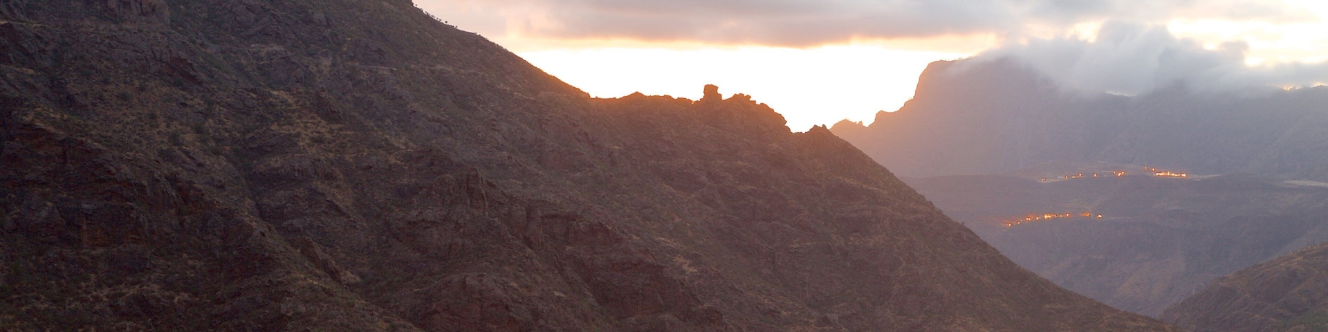 Tejeda which includes a sunset, a small town or village and mist or fog