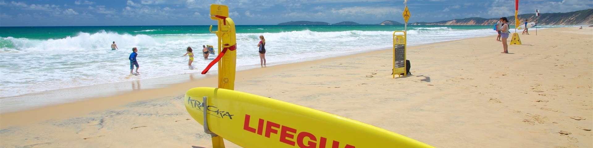 Rainbow Beach mostrando paisagens litorâneas, ondas e uma praia de areia