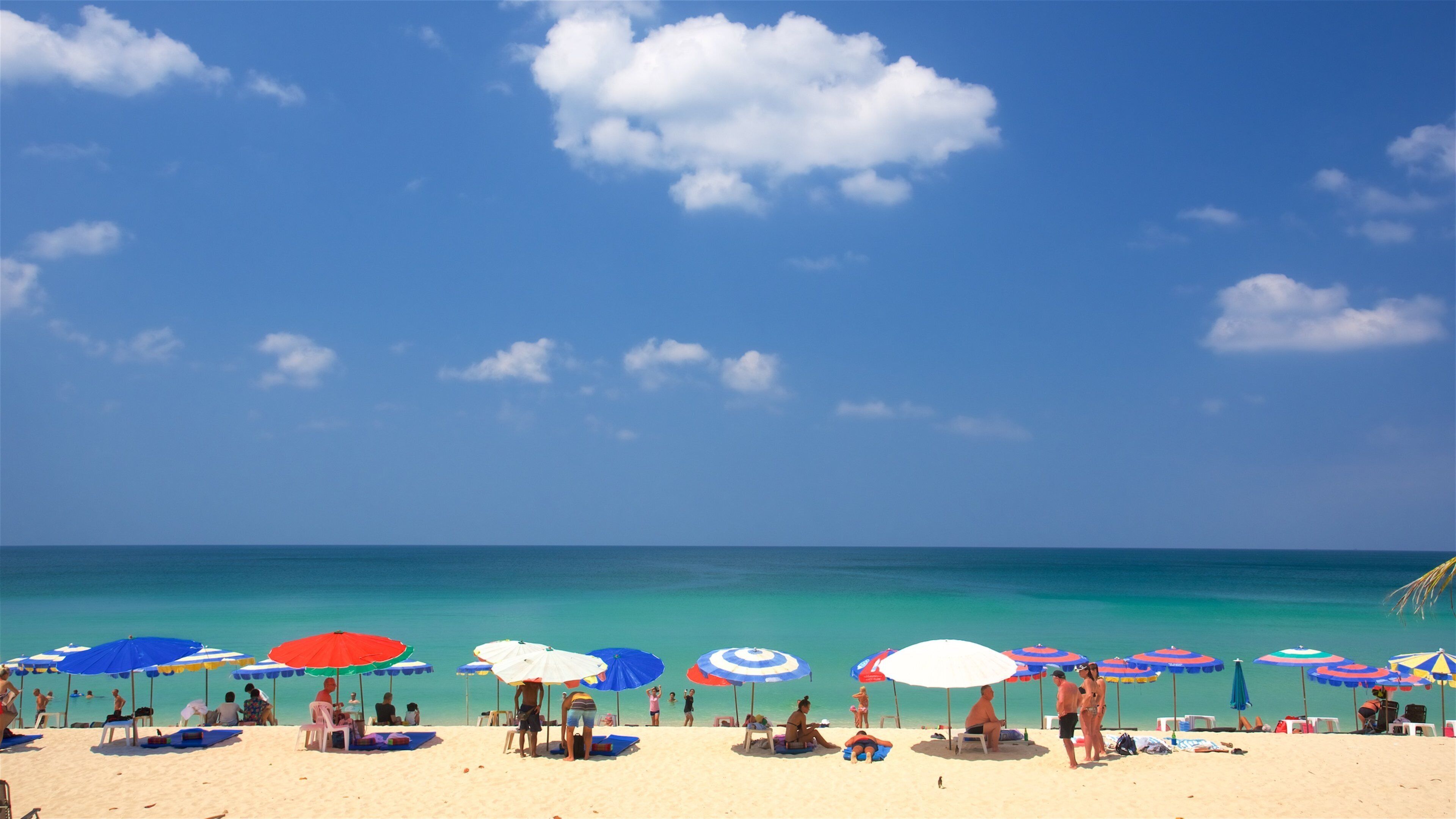 Surin Beach which includes a sandy beach and a pebble beach as well as a small group of people