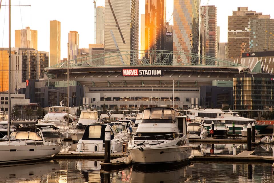 Uma marina com vários barcos atracados em frente ao Marvel Stadium.
