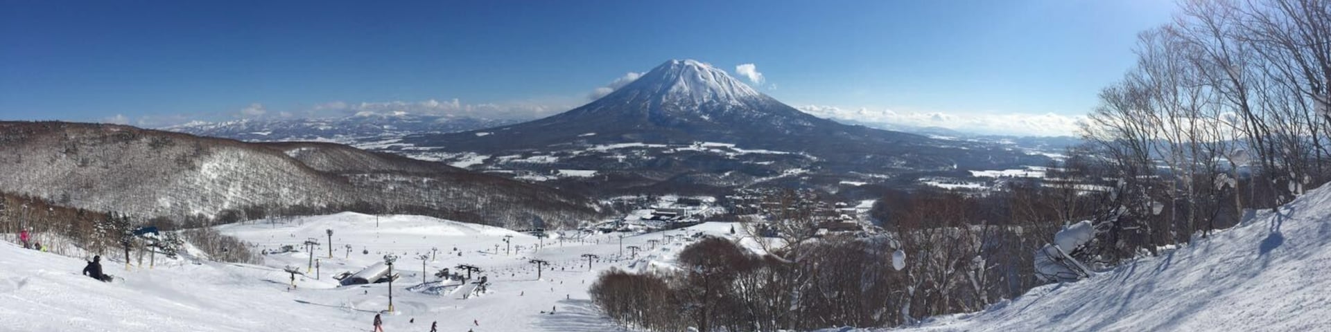Pista de esqui coberta de neve com montanha ao fundo.