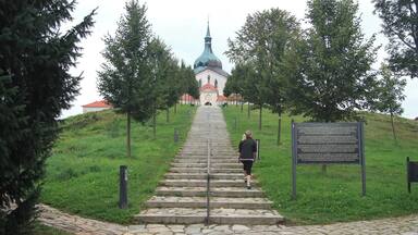 Escadaria de pedra que leva a uma igreja com cúpula verde.