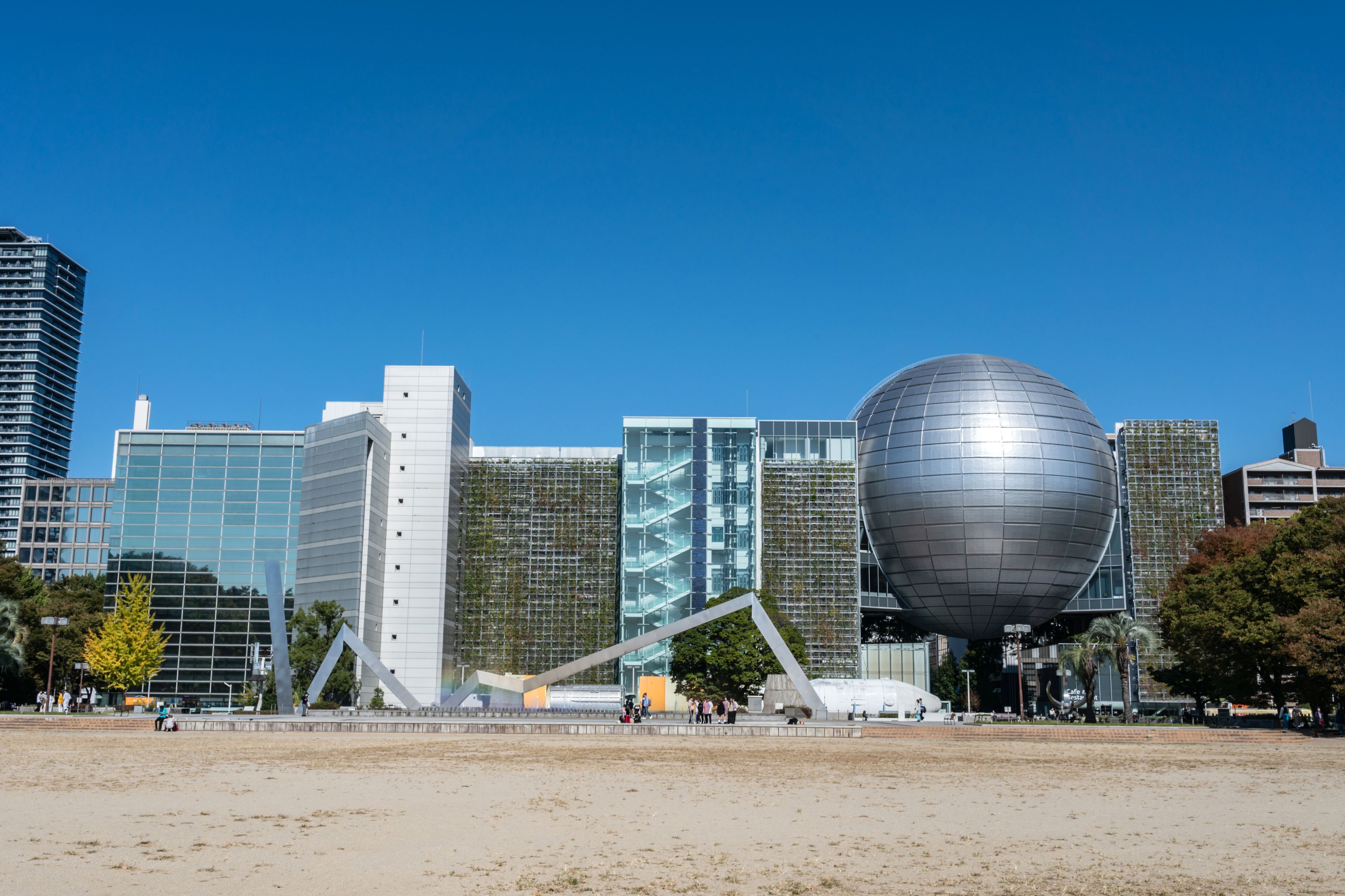 Paisagem urbana moderna com uma estrutura esférica destacada e edifícios contemporâneos.