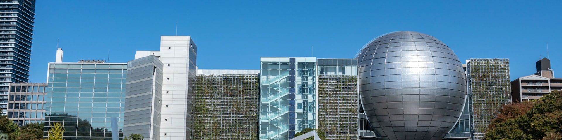 Paisagem urbana moderna com uma estrutura esférica destacada e edifícios contemporâneos.