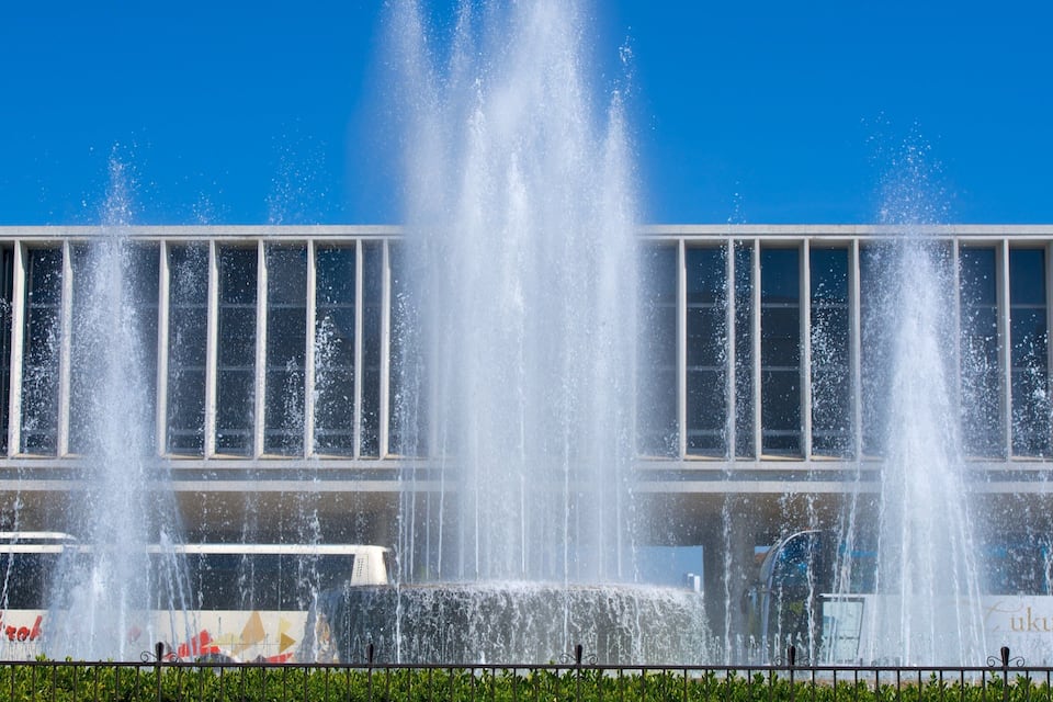 Um edifício com uma fonte de água na frente.