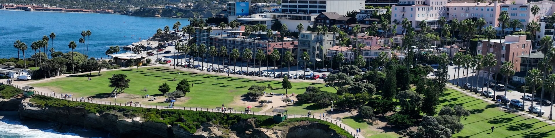 Paisagem urbana costeira com campo de golfe, praia e edifícios residenciais.