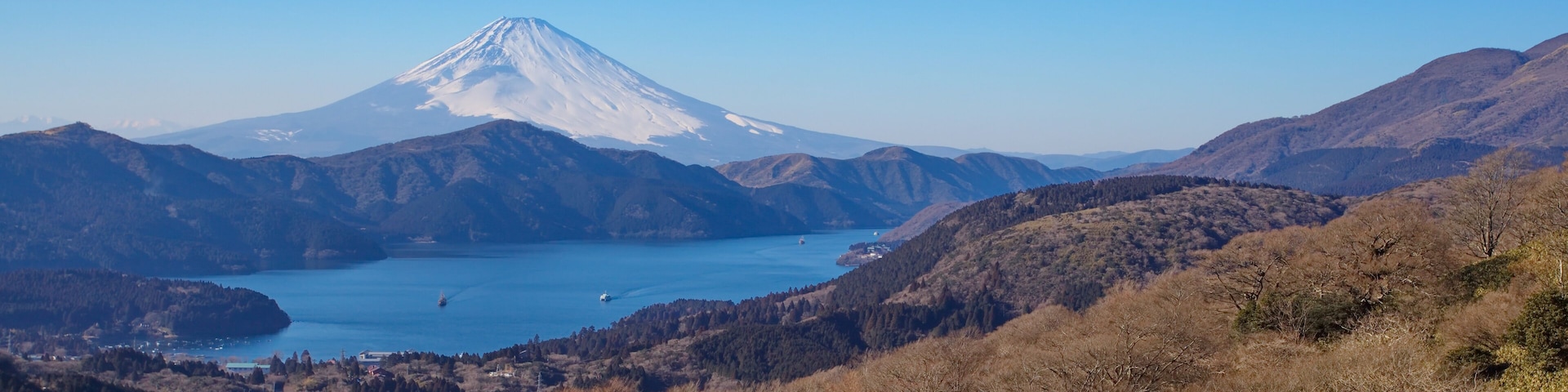 Uma montanha nevada, um lago e colinas ao redor.