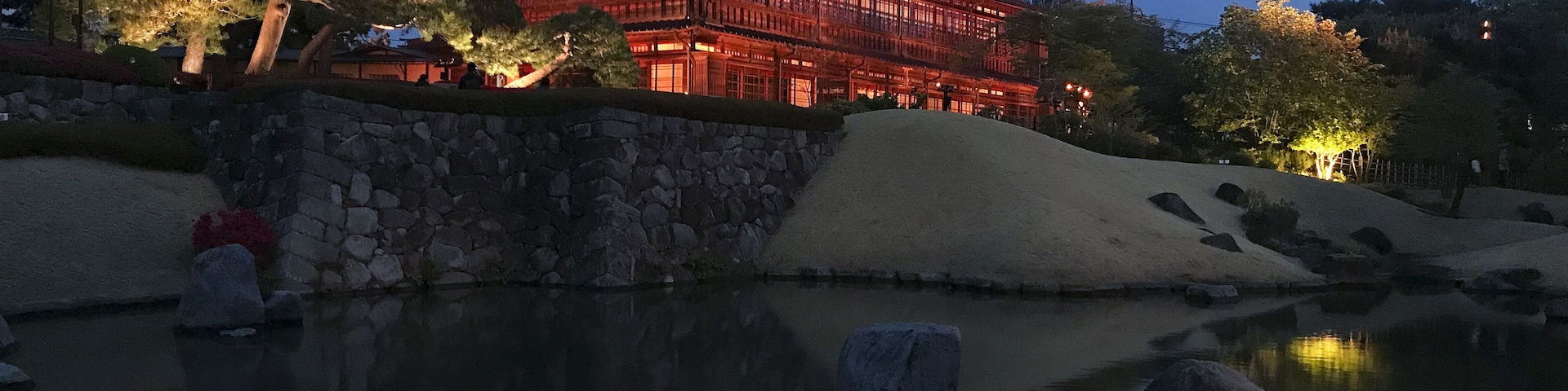 Um edifício japonês tradicional refletido na água.