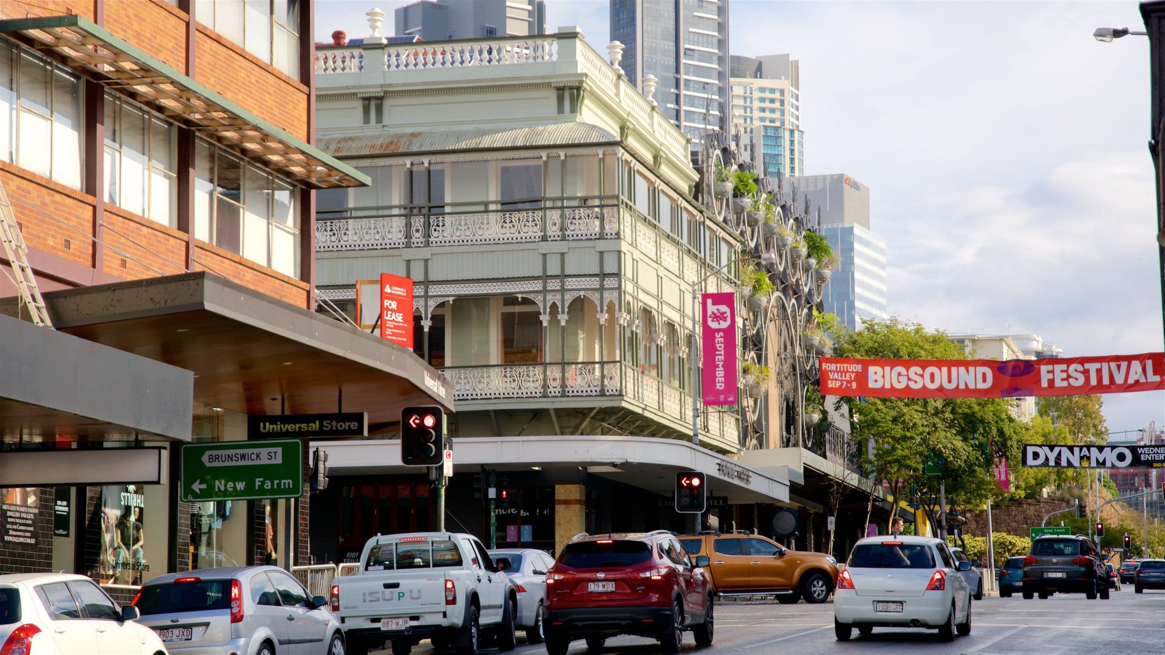 Uma rua urbana movimentada com carros, uma Universal Store e um cartaz do Festival Big Sound Fortitude Valley.