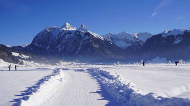Pista de esqui coberta por neve, com montanhas ao fundo.