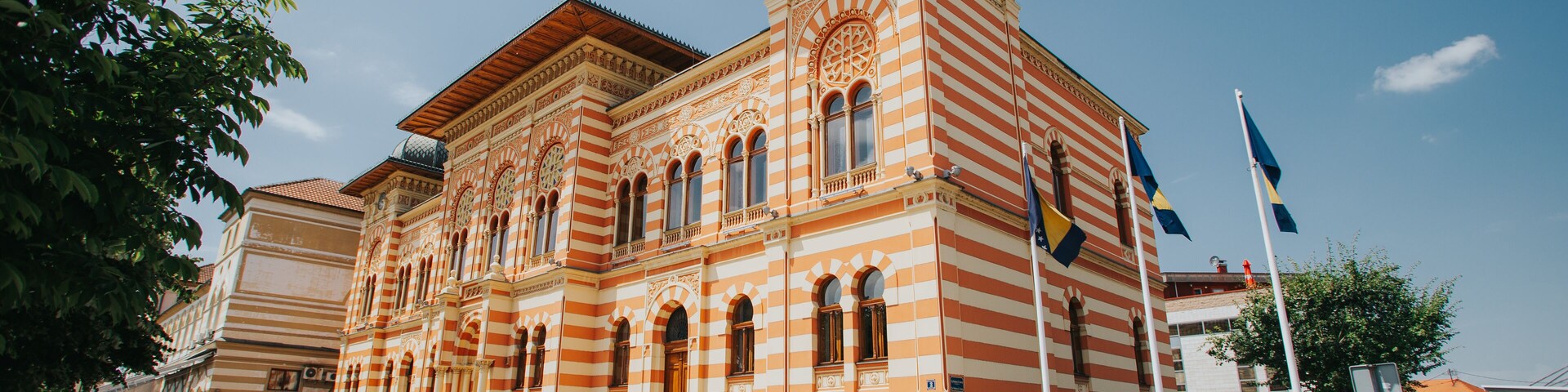 Um edifício histórico com arquitetura listrada e uma torre do relógio.
