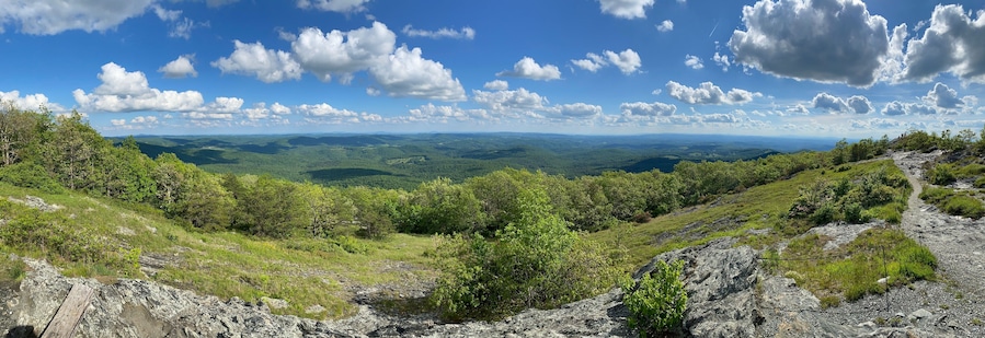 Paisagem montanhosa com céu claro e nuvens esparsas.