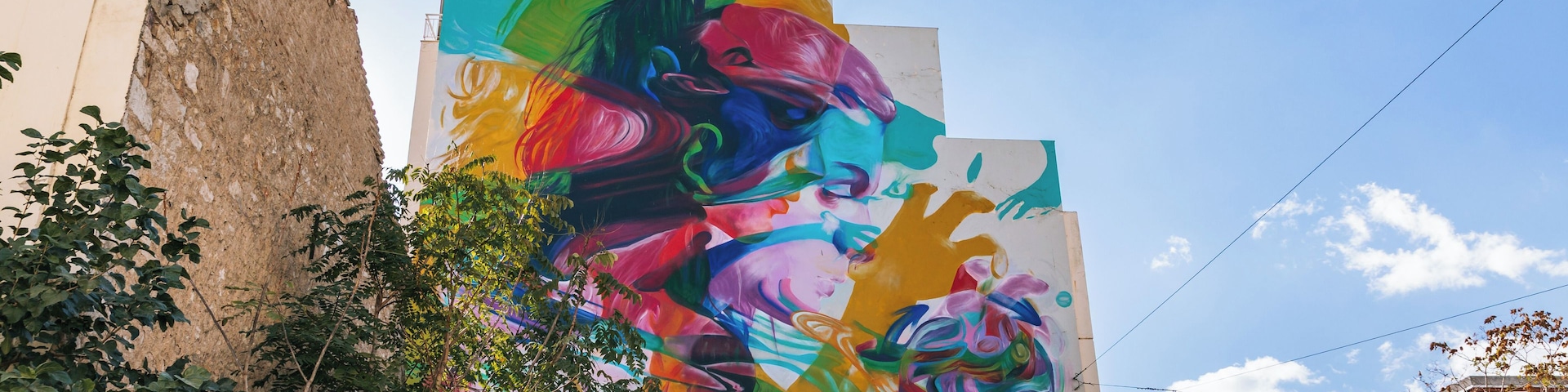 Um mural colorido numa construção, com um céu azul claro ao fundo.