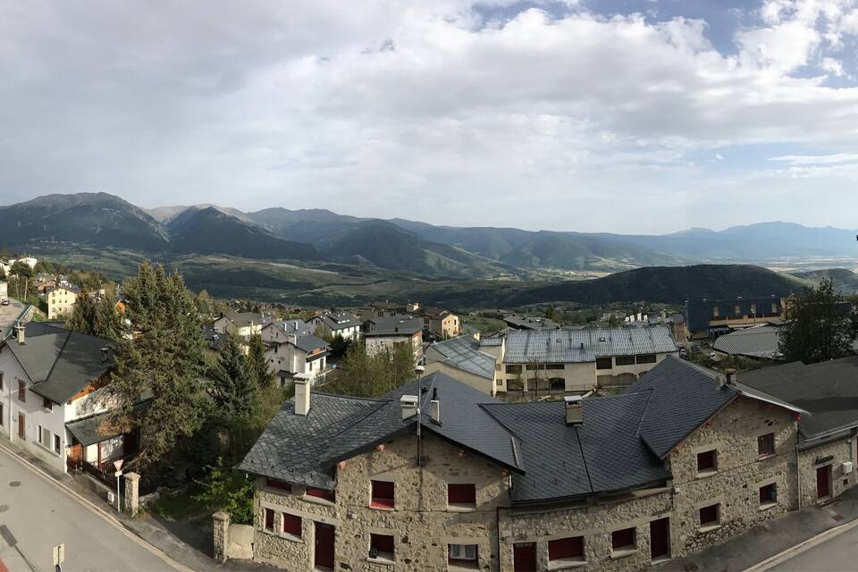 Paisagem montanhosa com uma aldeia aninhada entre as colinas.