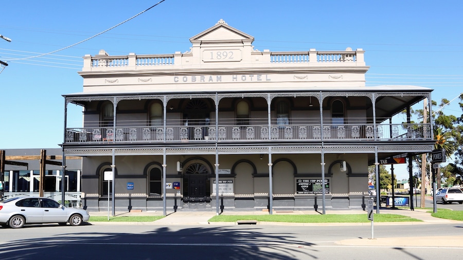 A historic building labeled "Cobra Hotel" with a balcony and a year "1892" on the facade.