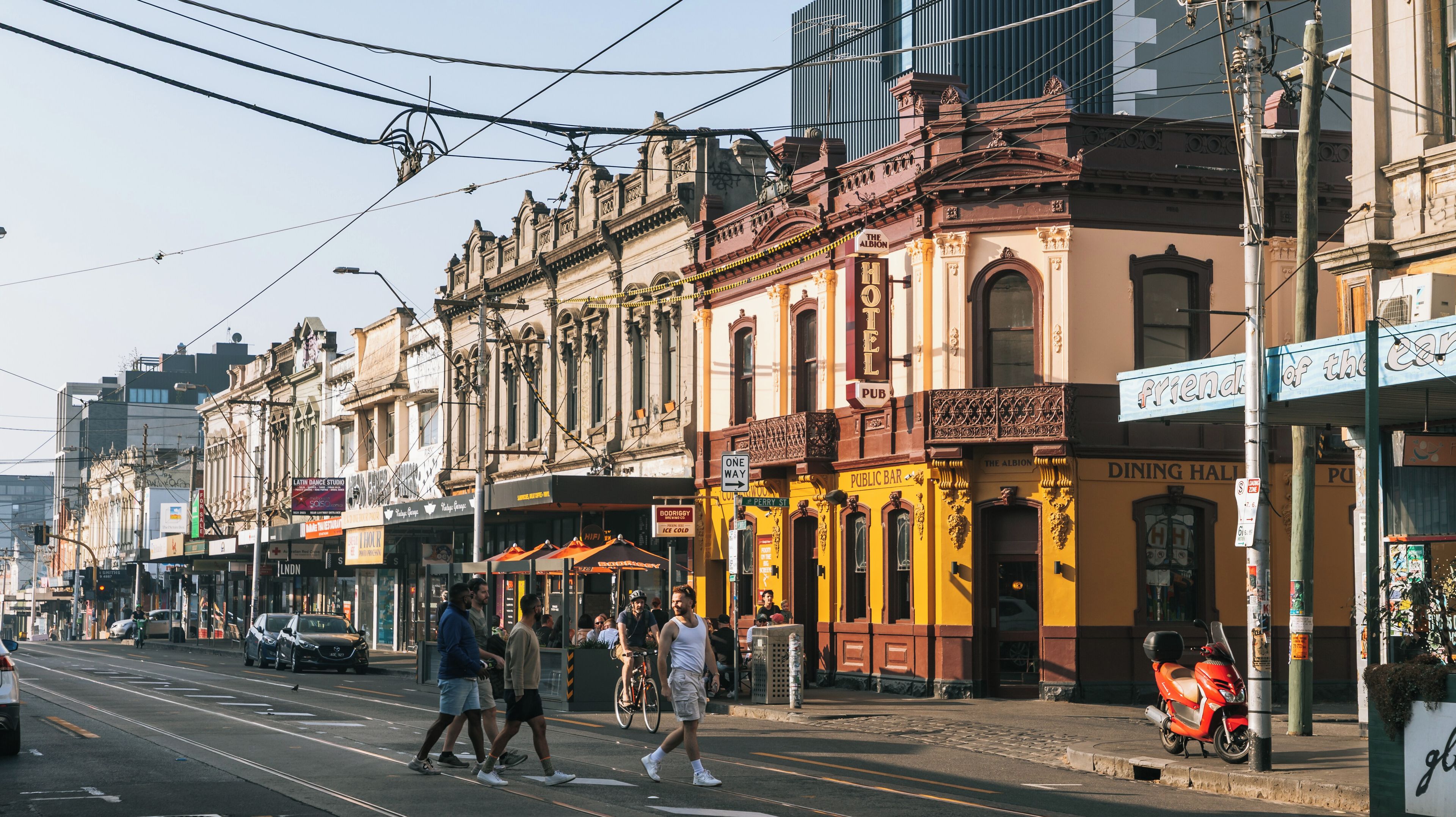 Rua repleta de edifícios históricos, um bar público e um salão de refeições.