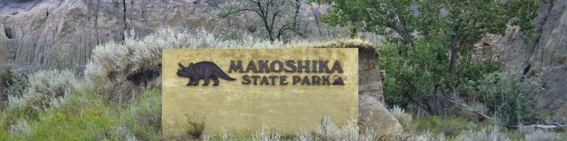 Placa do Parque Estadual Makoshika com silhueta de alce.