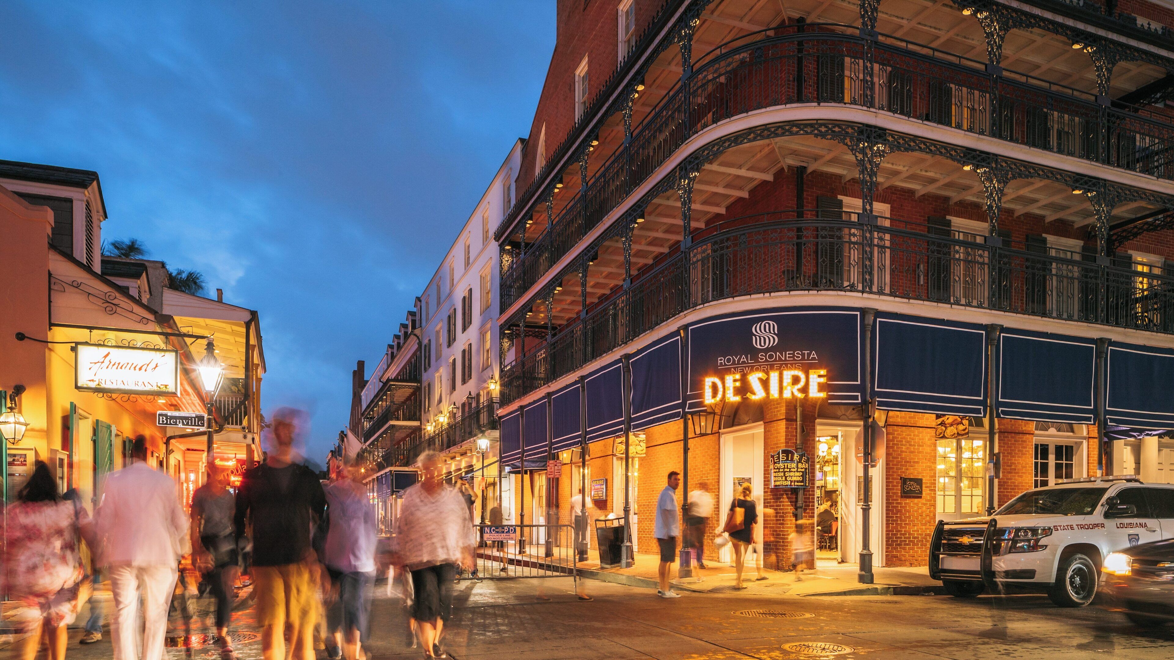 Evening stroll along Bourbon Street in the lively French Quarter of New Orleans showcasing vibrant nightlife and historic architecture