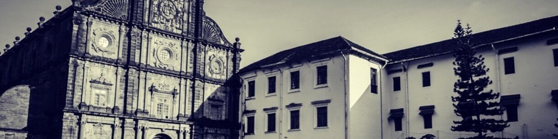 Um edifício histórico com uma torre do relógio e fachada branca.