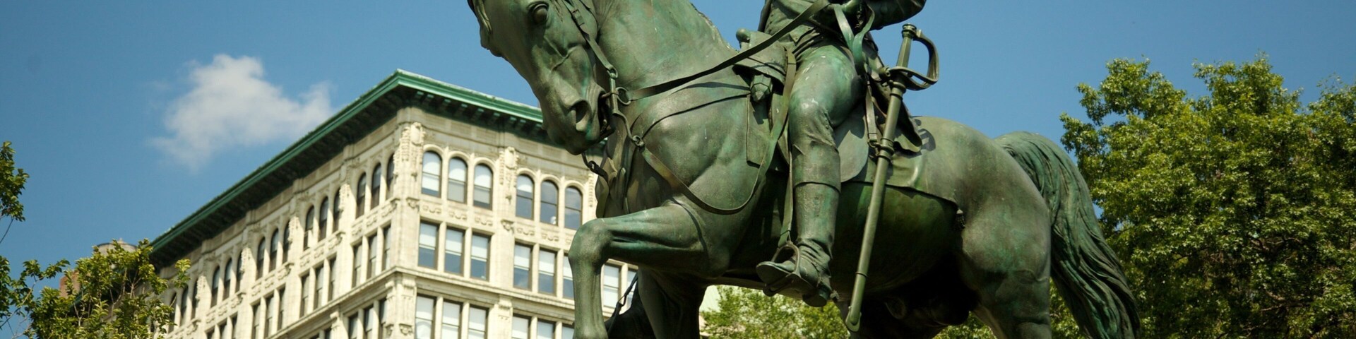 Union Square Park in New York City features a statue of George Washington on horseback among lush trees and vibrant outdoor activity