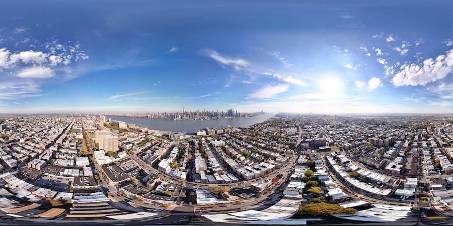 Vista panorâmica de uma cidade com rio, área urbana densa e horizonte distante.