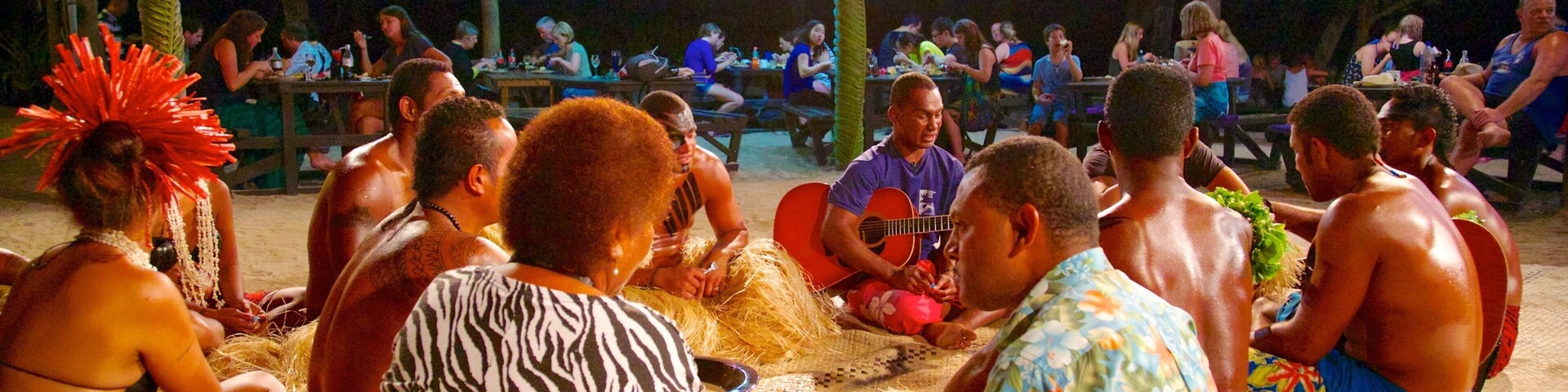 Robinson Crusoe Island which includes a beach bar, outdoor eating and night scenes