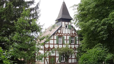 Uma casa tradicional em estilo de enxaimel, com telhado íngreme e uma pequena torre.