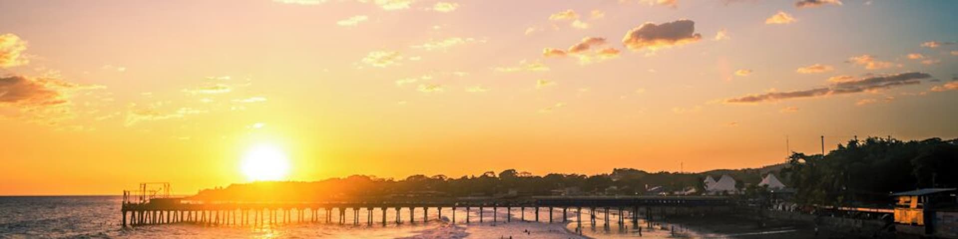The sun setting behind the pier of La Libertad, in El Salvador.