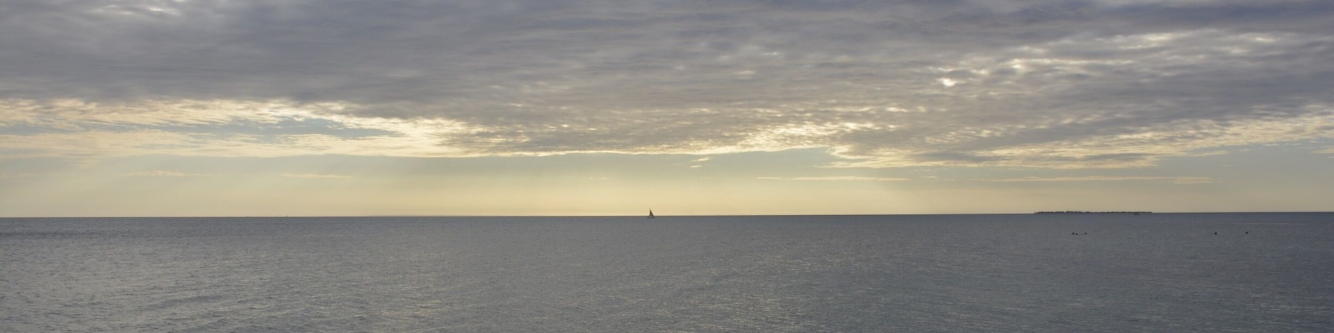 Perfect balance between the ocean and the clouds during a beautiful sunset at the beach. Do you see the sailboat? Hotel Mbweni Ruins near Stone Town, Zanzibar.