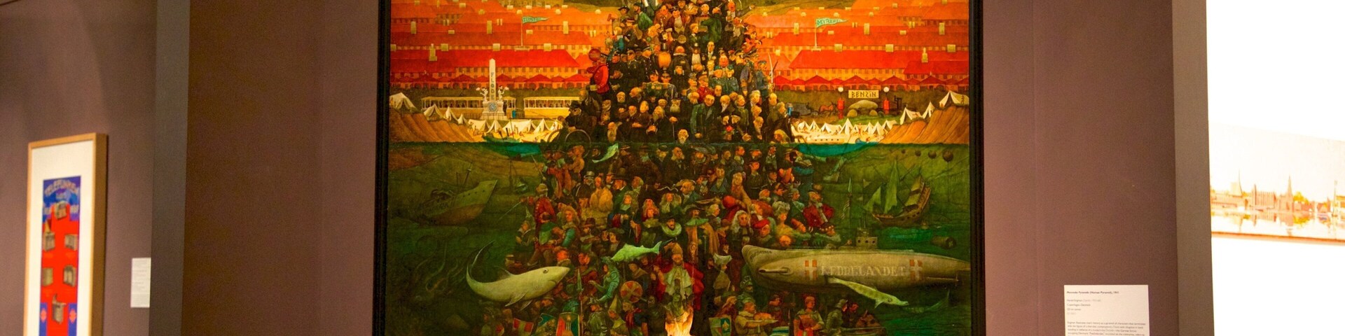 Uma pintura grande mostrando uma pirâmide de pessoas com paisagem urbana ao fundo.