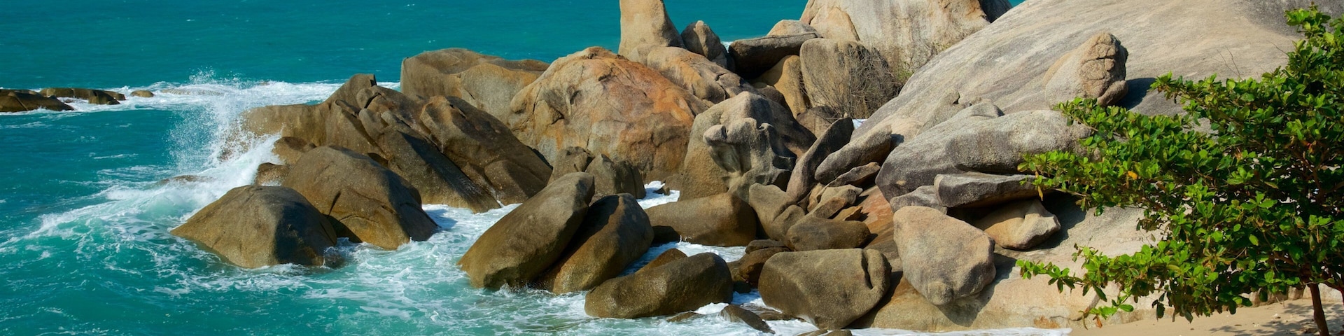 Hin Ta and Hin Yai showing a beach, surf and rugged coastline