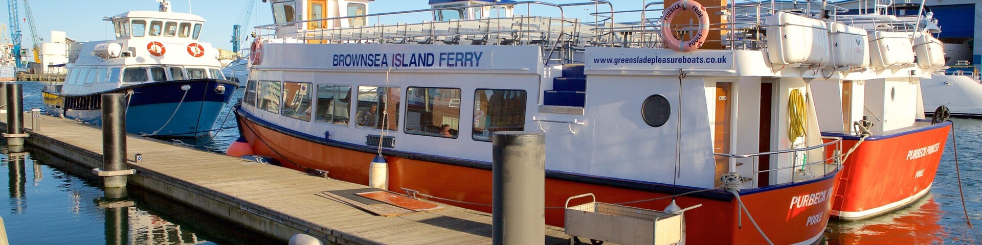 Um ferry atracado em um cais, com outros barcos.