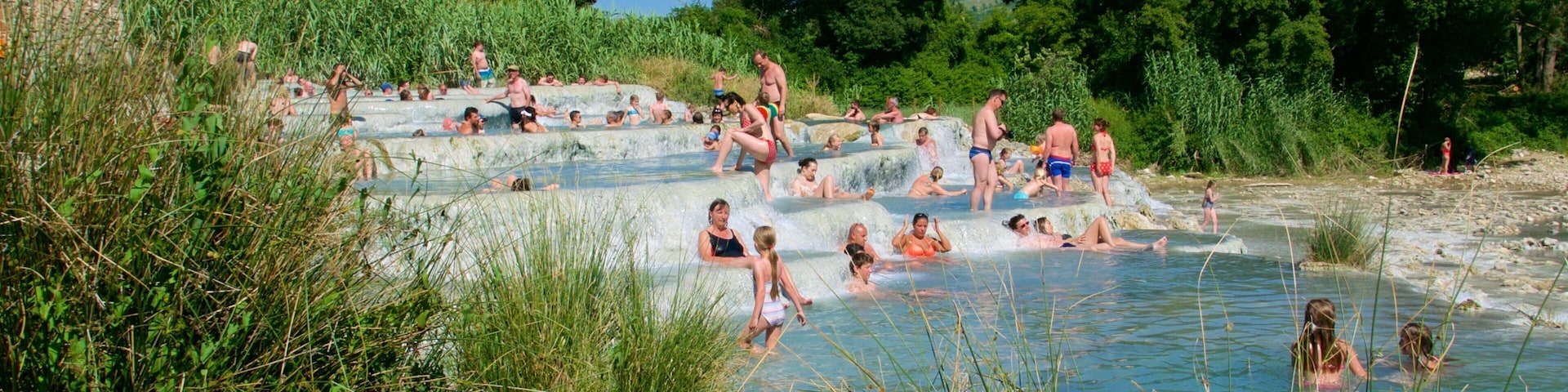 Grosseto caracterizando uma fonte termal e natação assim como um grande grupo de pessoas