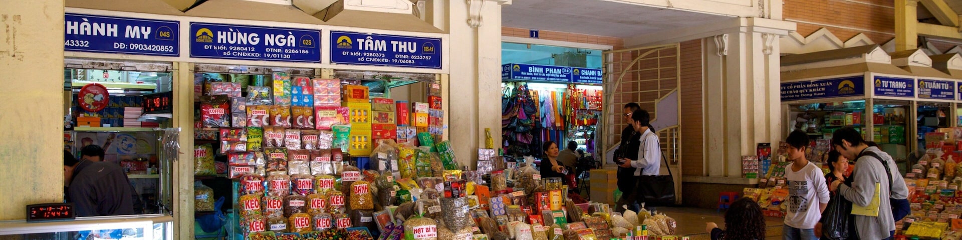 Um mercado com diversos quiosques vendendo lanches e bebidas.