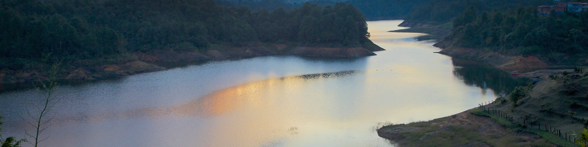 Rock of Guatape which includes a sunset, landscape views and forest scenes