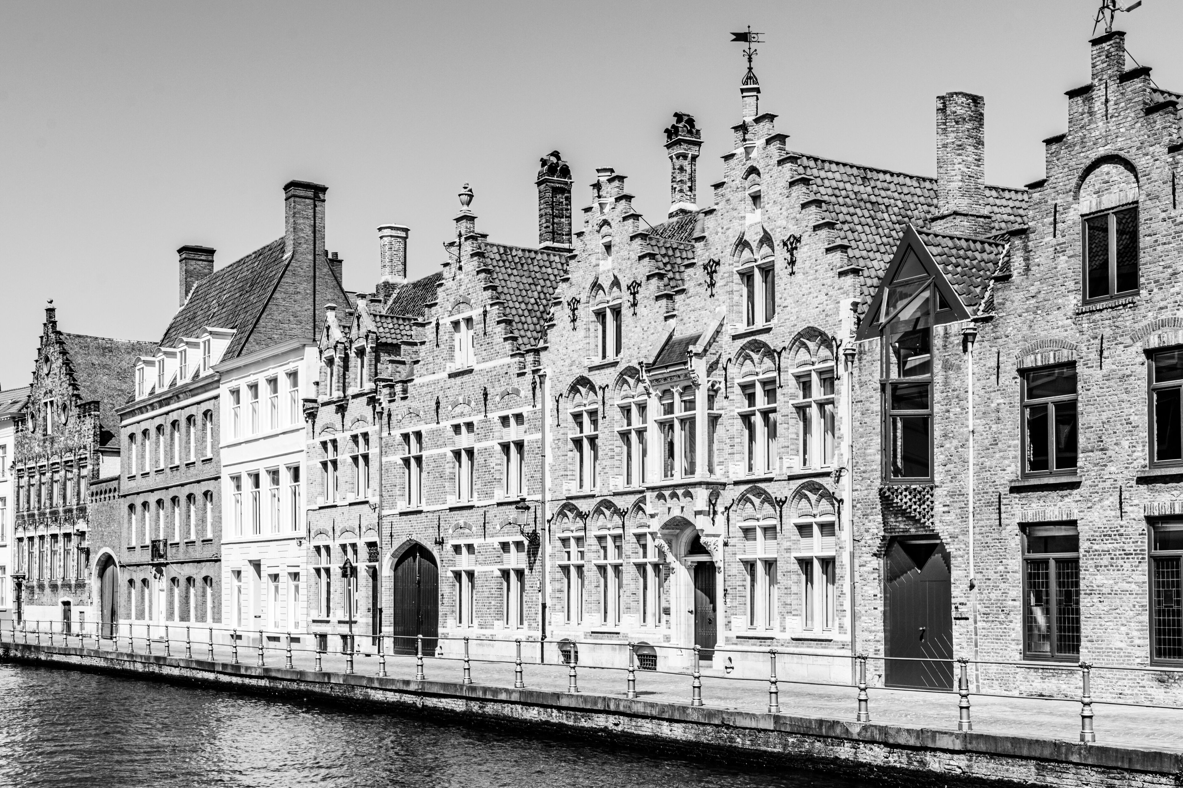 Um edifício histórico com arquitetura elaborada, um canal e uma ponte.
