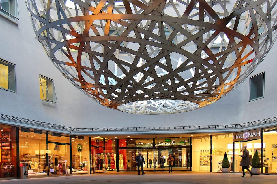 Um centro comercial com uma grande estrutura esférica acima.