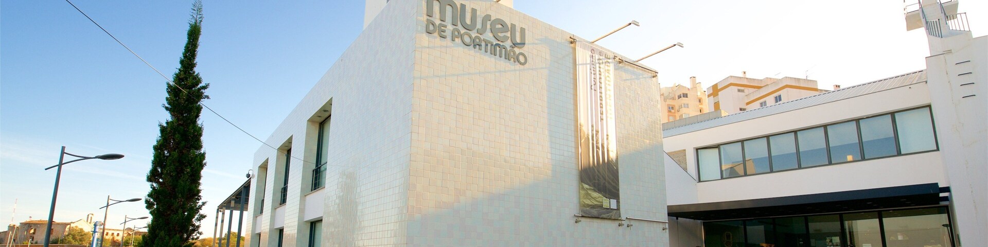 Um edifício moderno com fachada em azulejos e arco azul, com a inscrição 'Museu de Arte Moderno'.