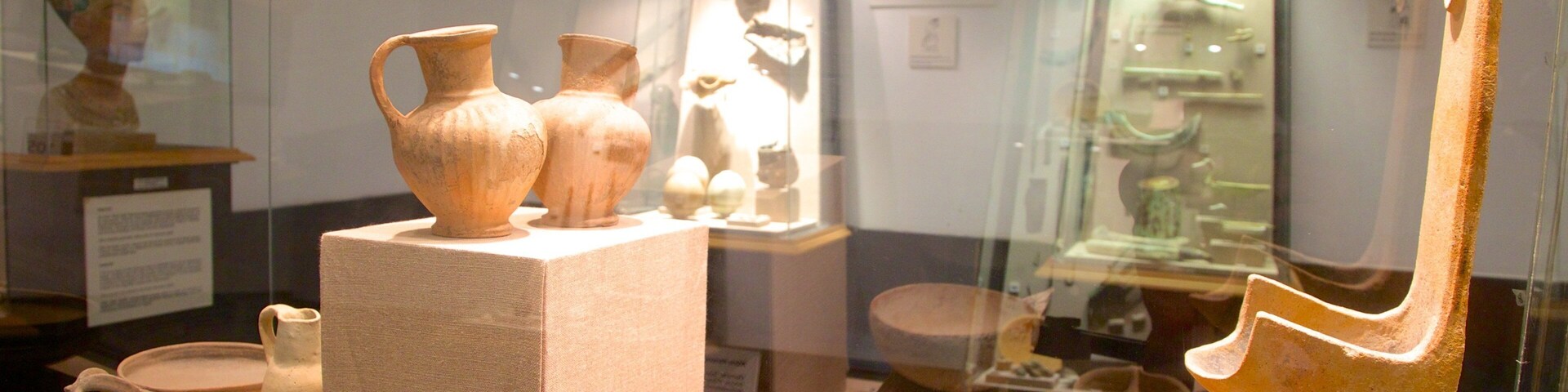 Cerâmica antiga, incluindo tigelas e jarros, exposta em um museu.