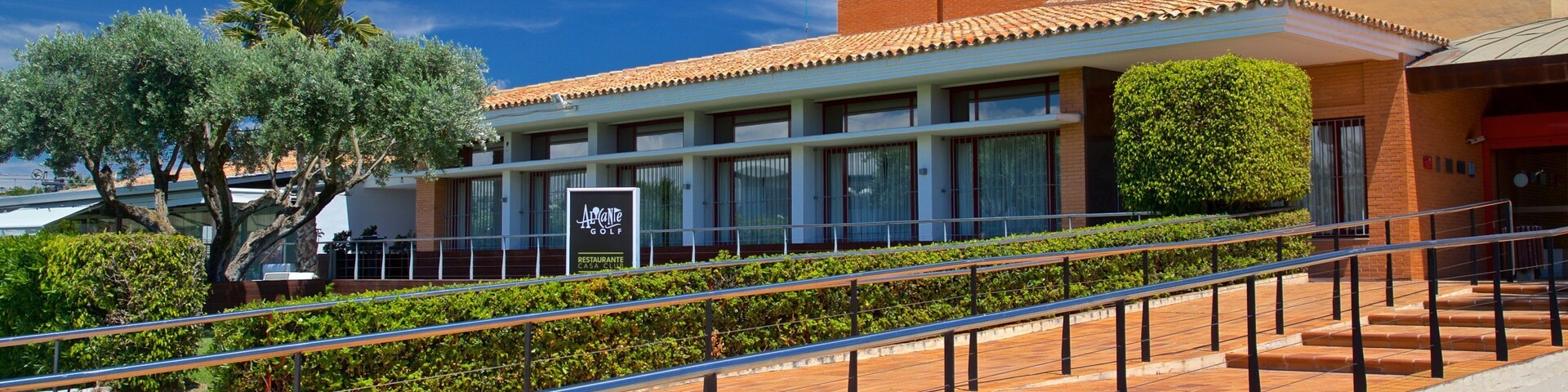 Um edifício moderno com fachada de tijolos, telhado telhado e uma placa indicando um restaurante.