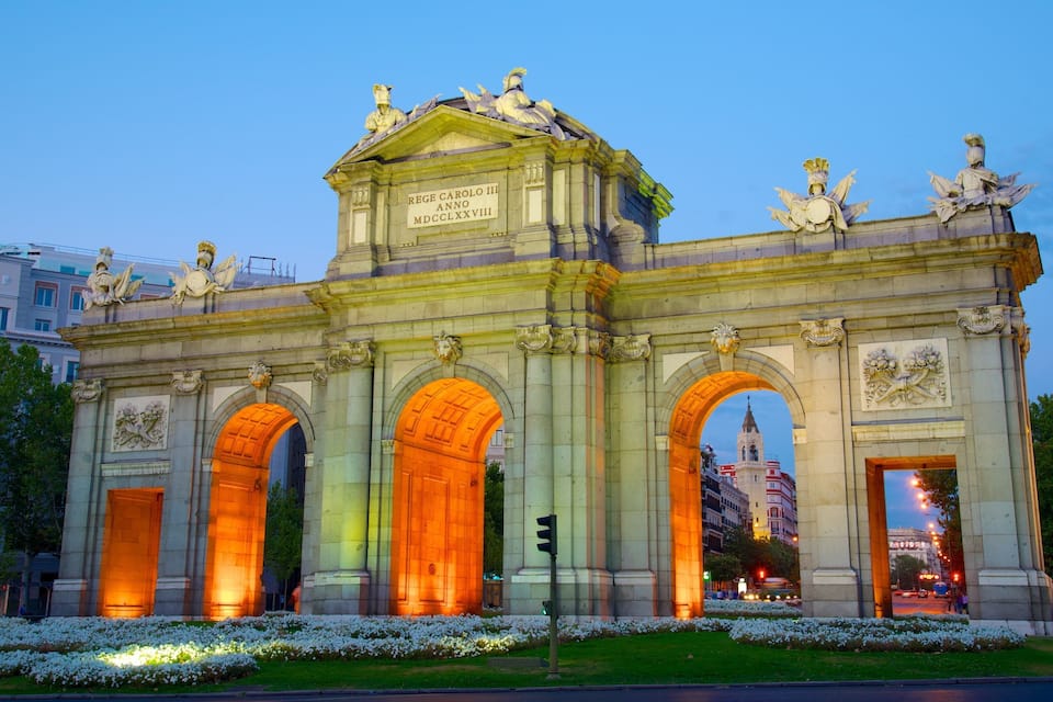 O Arco do Triunfo em Roma, Itália, com arcos e estátuas iluminadas.