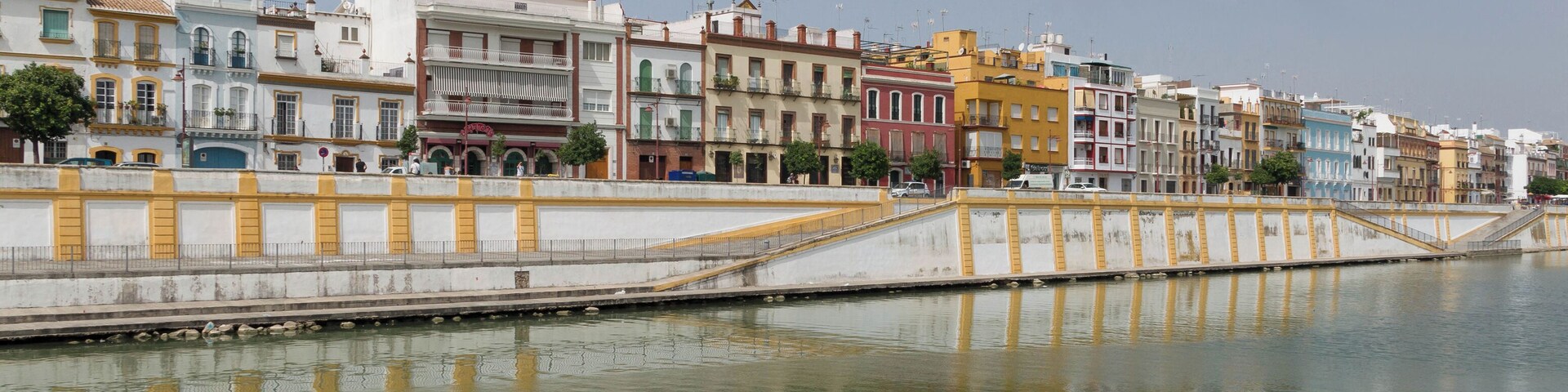 Um calçadão com edifícios coloridos ao longo do rio.