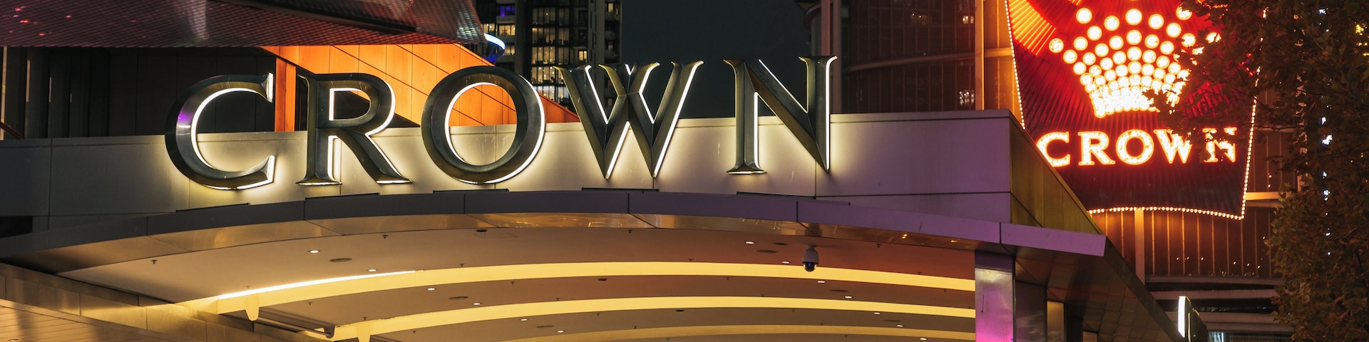 Um edifício com uma grande placa iluminada que diz 'CROWN'.