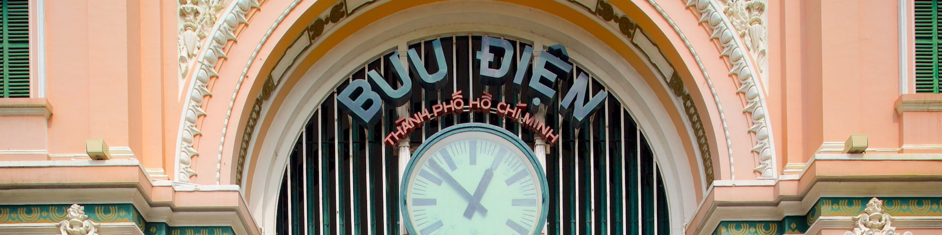 A clock with ornate carvings above it, and the words "BUU DIEN" in Vietnamese.